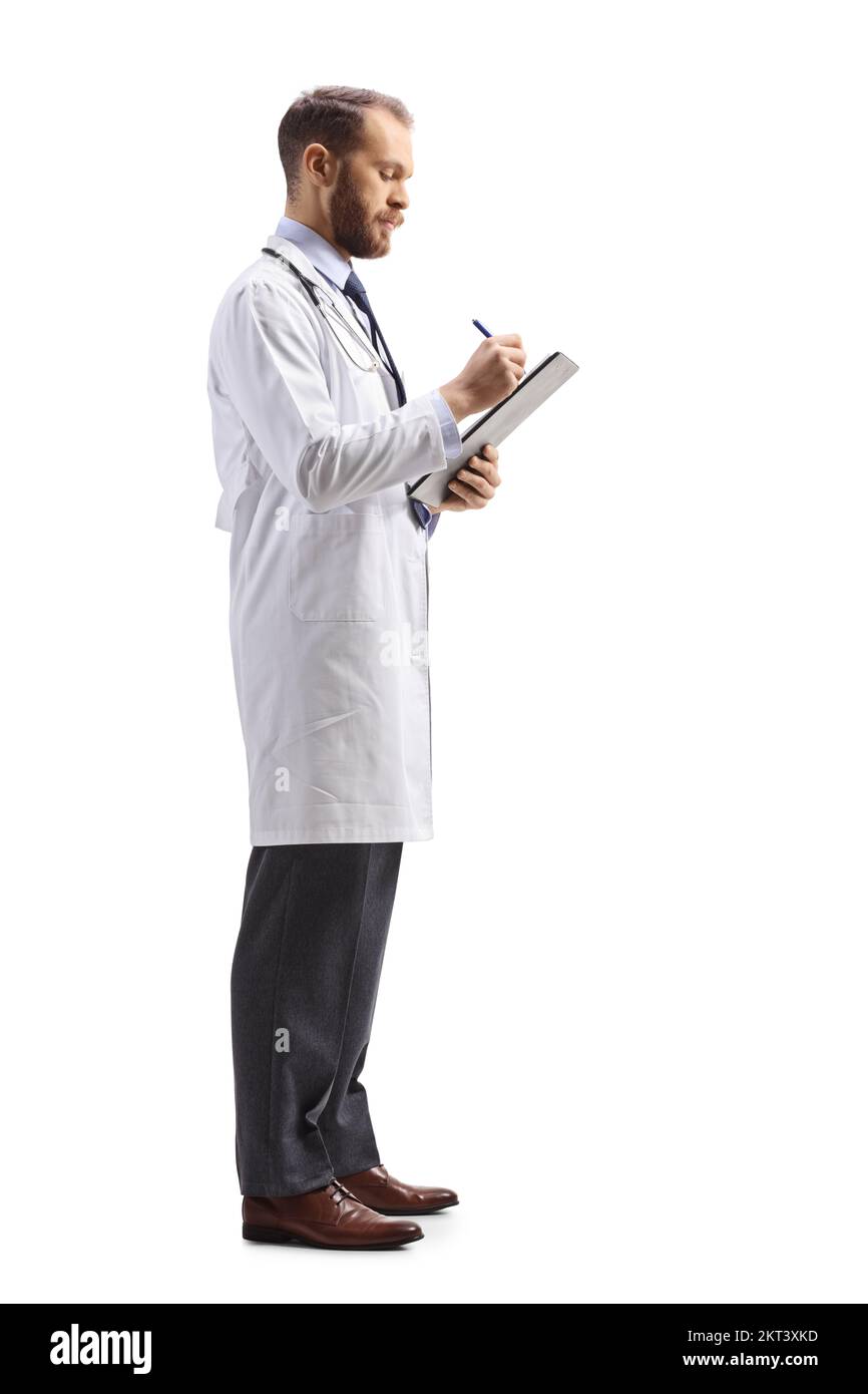 Full length profile shot of a male doctor standing and writing a ...