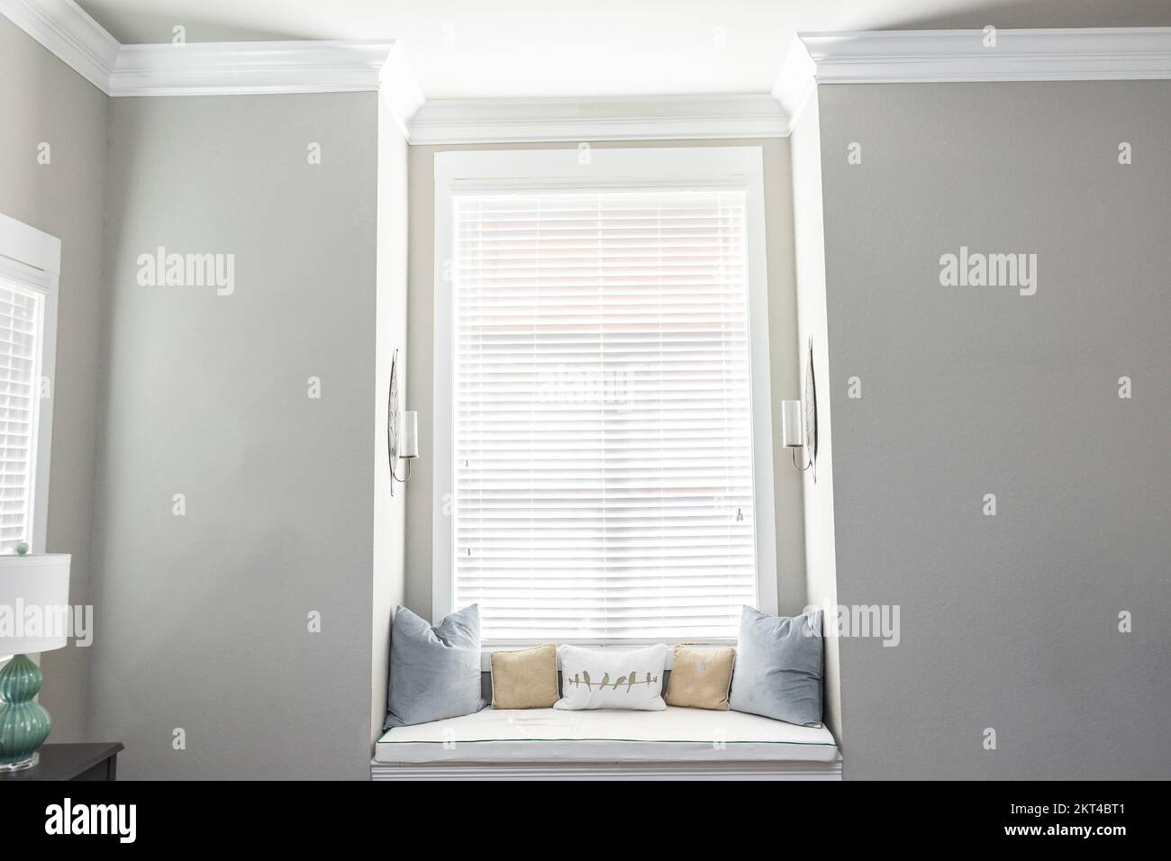 A light and bright gray master bedroom with a window seat for reading ...