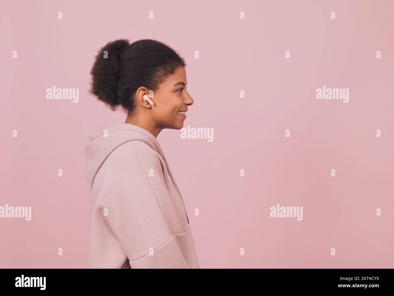 Happy young black woman in wireless headphones. Side-profile portrait ...