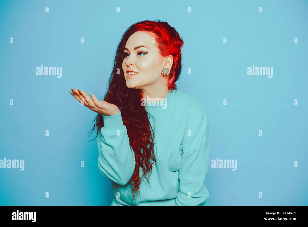Woman in a blue sweater on a blue background posing. Beautiful brunette ...