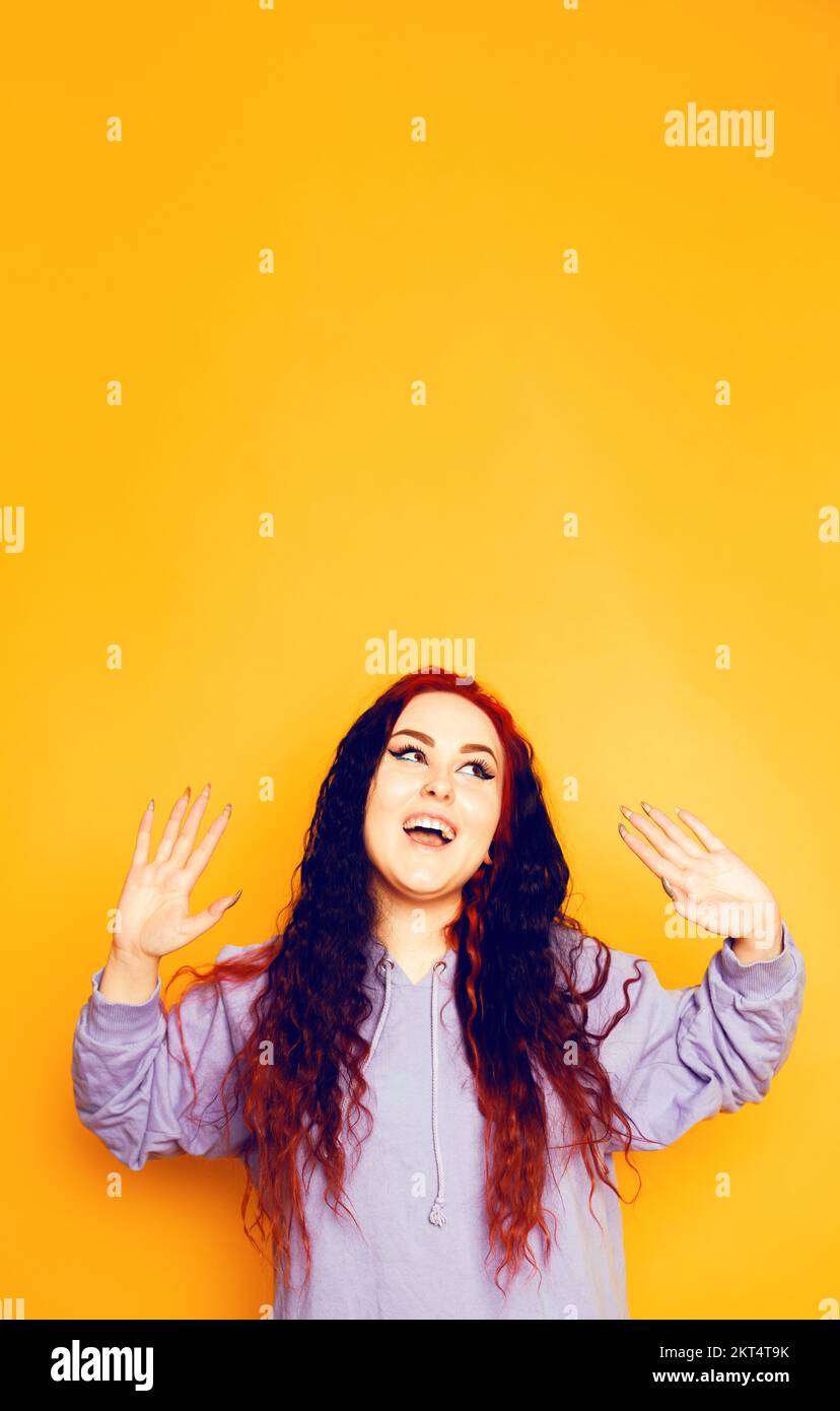 A girl with frizzy and split ends on an orange background in a blue ...