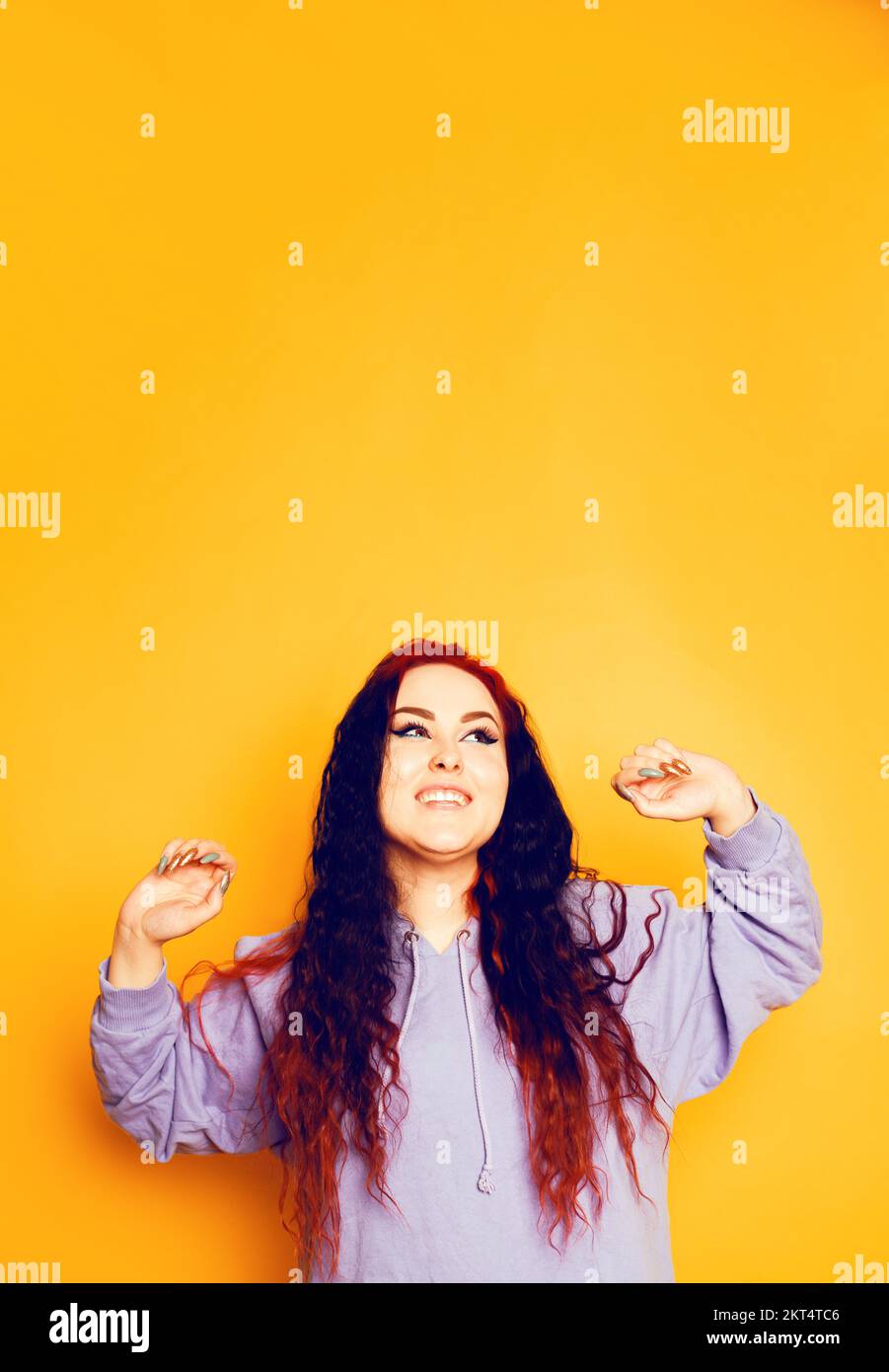 A girl with frizzy and split ends on an orange background in a blue ...