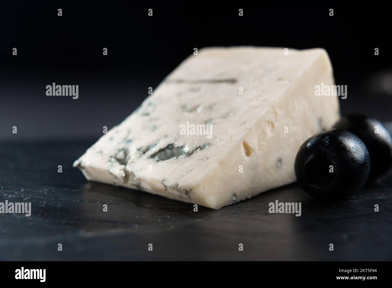 French cheese, roquefort with olives on plate, closeup. French ...