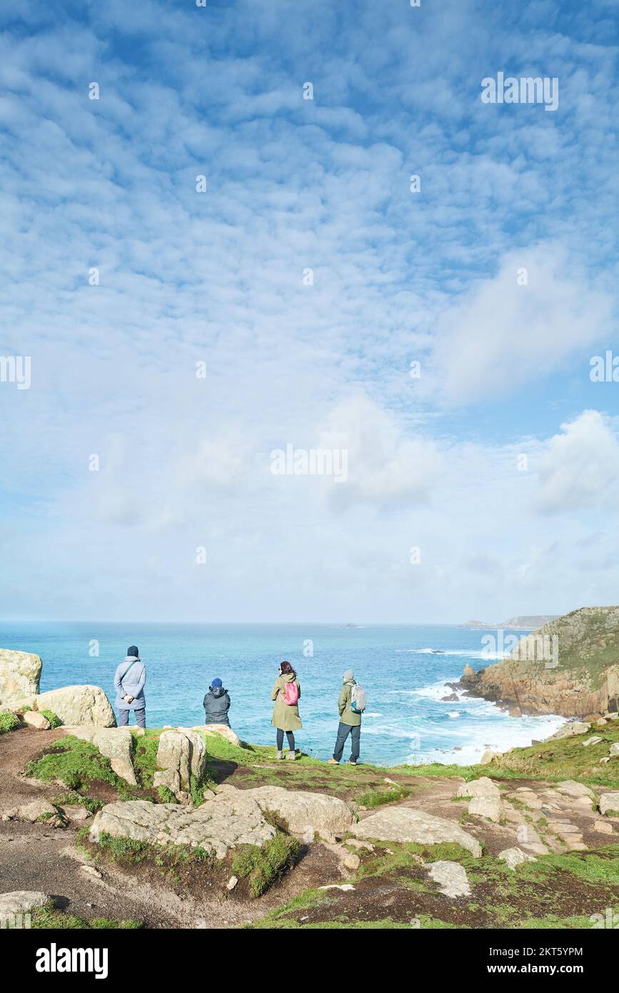 Four people stand and admire the view from a cliff edge by the south ...