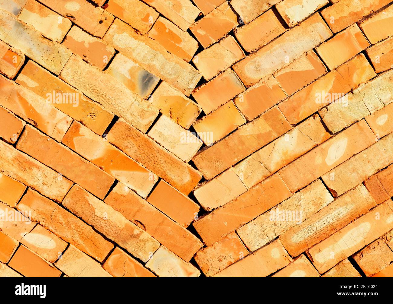 The texture of an orange brick stacked diagonally, illuminated by the ...
