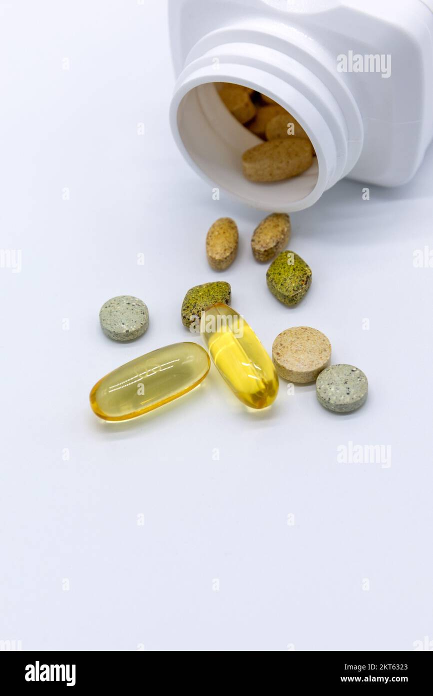 Nutritional supplements in white bottle packaging with dispersed pills ...