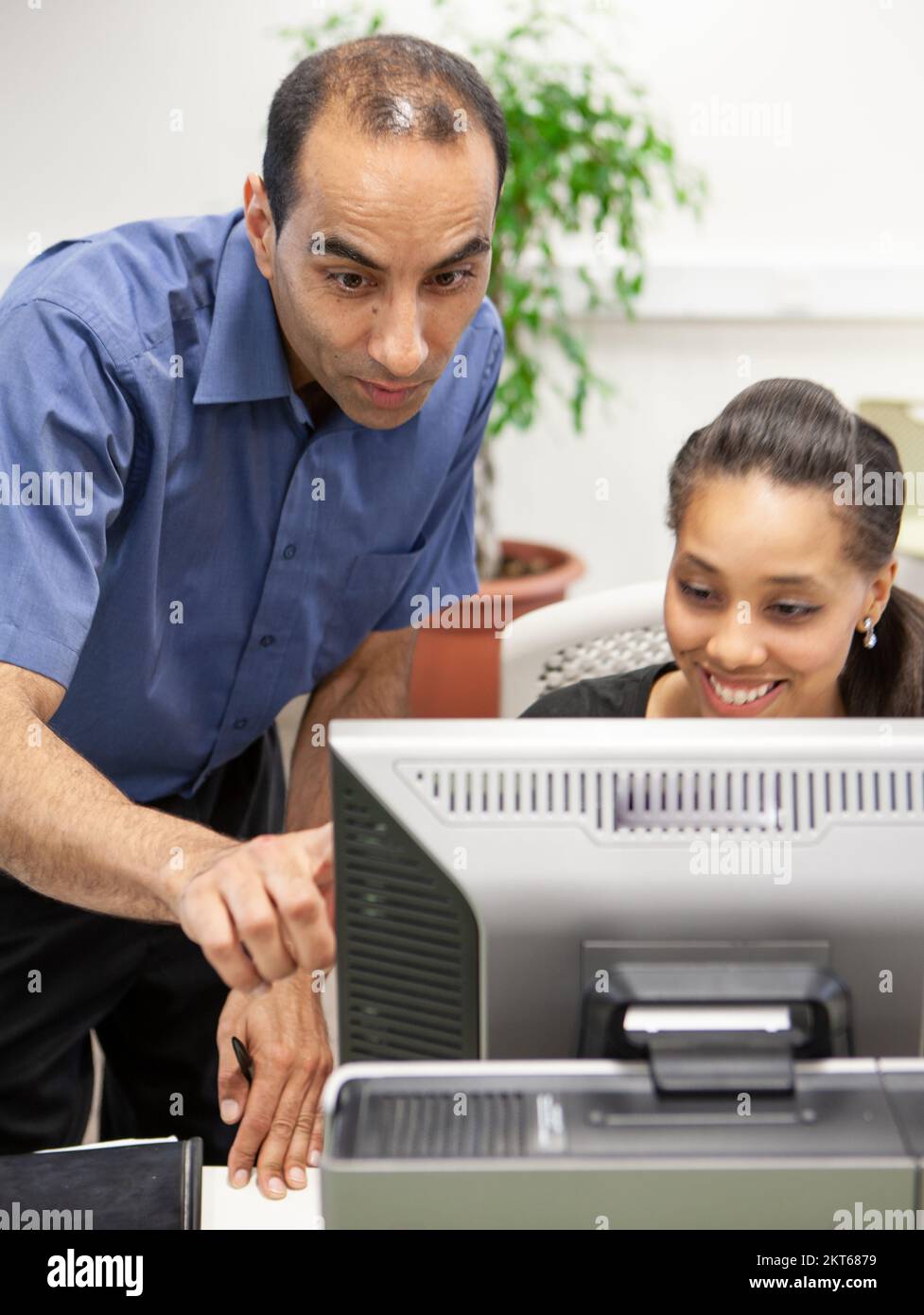 Computer Studies; Teacher and Student. A technology tutor helping his ...