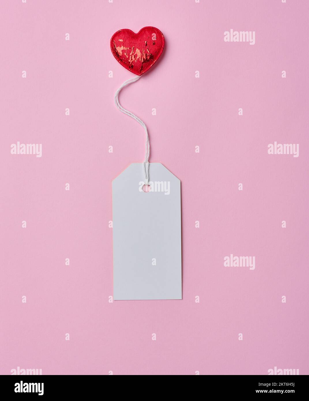 Blank white cardboard tag on white rope, pink background Stock Photo ...