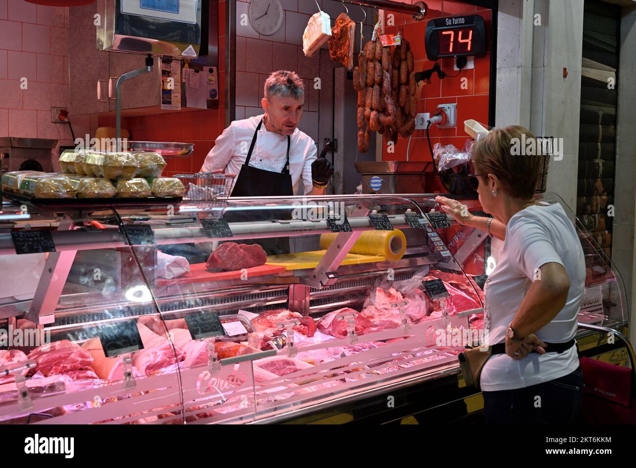 Customer selecting meat at small traditional butchers stall in Mercado ...