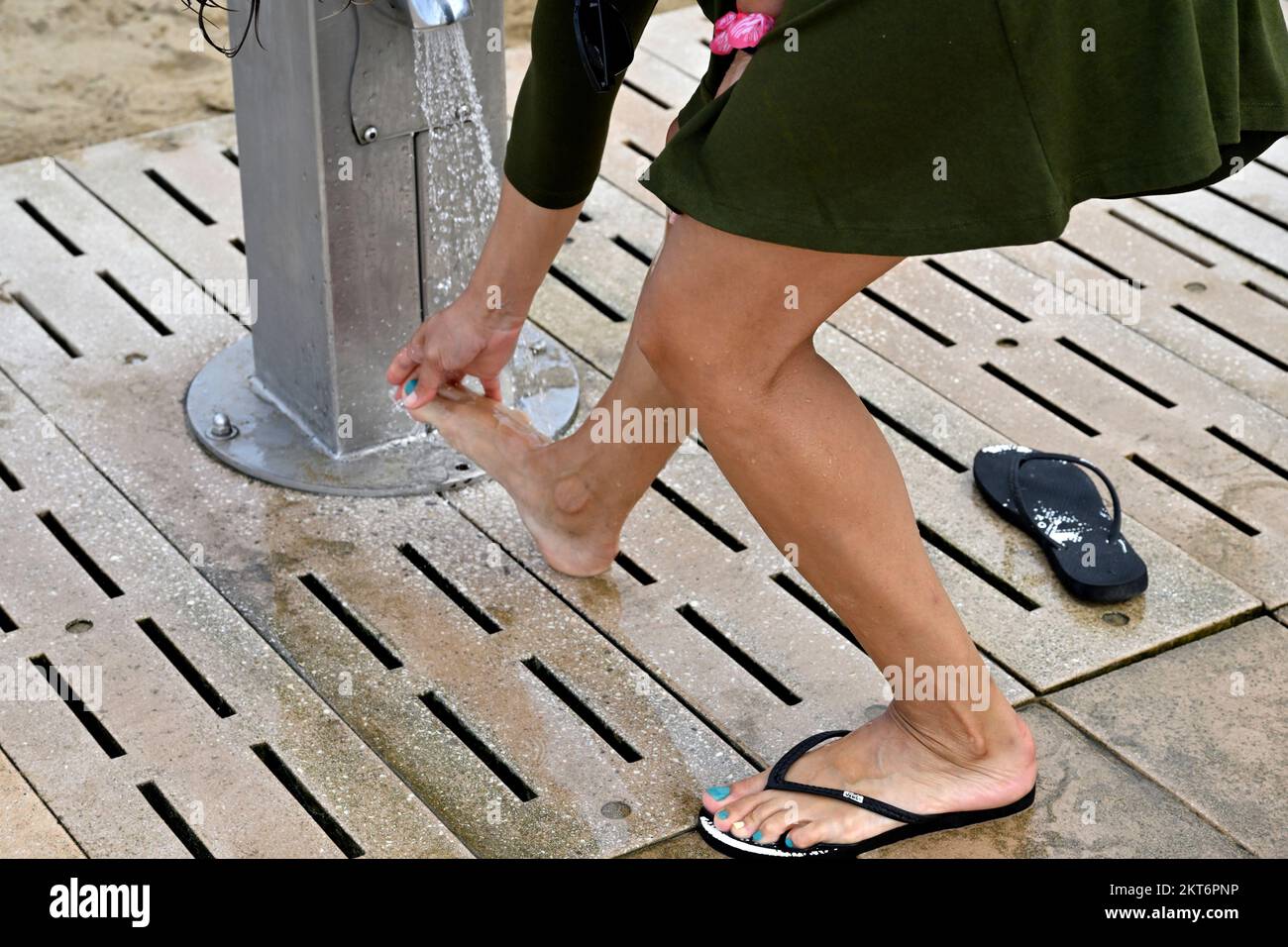 Washing sand from beach off feet Stock Photo - Alamy