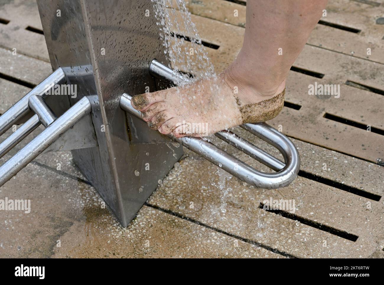 Washing sand from beach off feet Stock Photo - Alamy