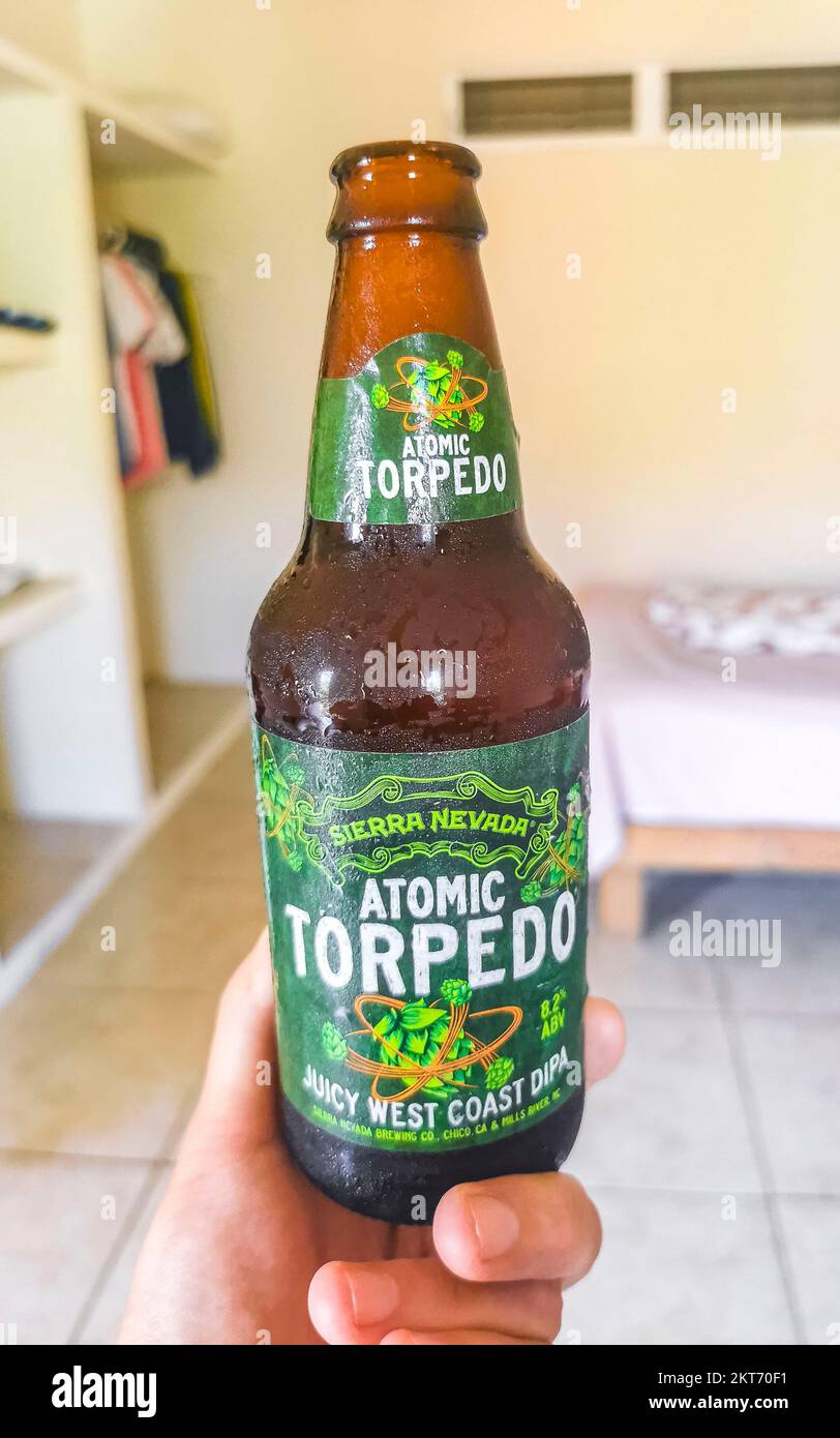 Beer bottle Atomic Torpedo in hand drinking alcohol in Playa del Carmen ...