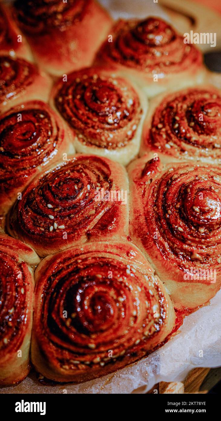 Freshly baked cinnamon buns with spices and cocoa filling on parchment ...