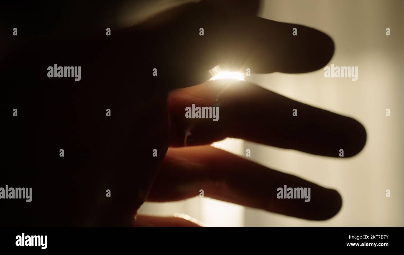 male hand playing with sunlight glare coming through window, wide photo ...