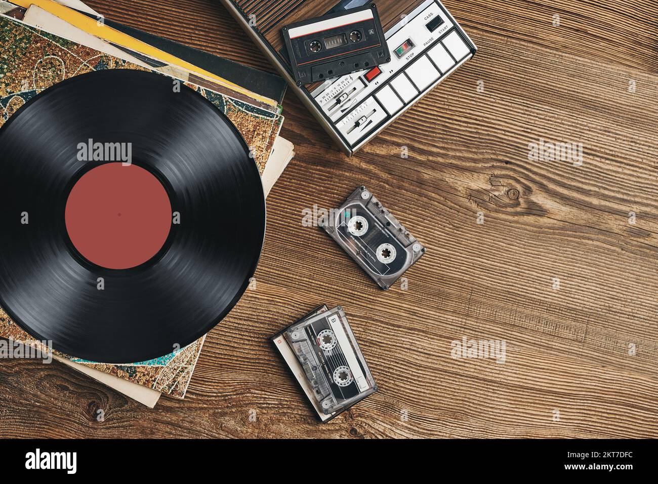Vinyl records, cassette tapes and cassette recorder on wooden table ...