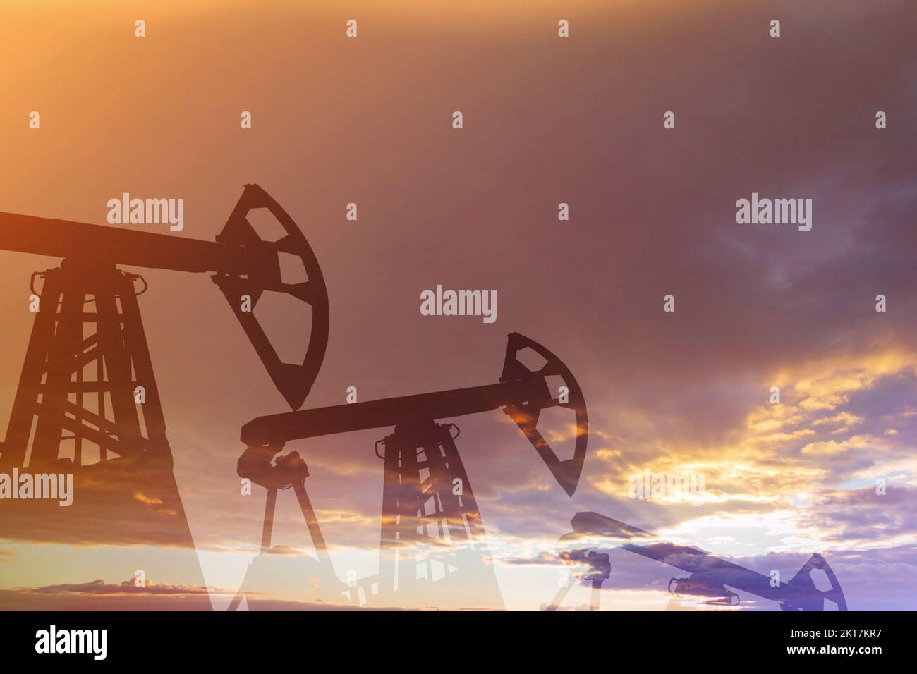 Oil production against backdrop of sunset. Rigs. Oilfield Stock Photo ...