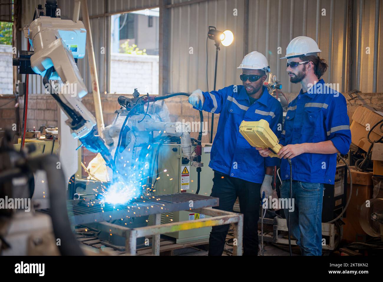 Two engineers mechanic using computer controller Robotic arm for ...