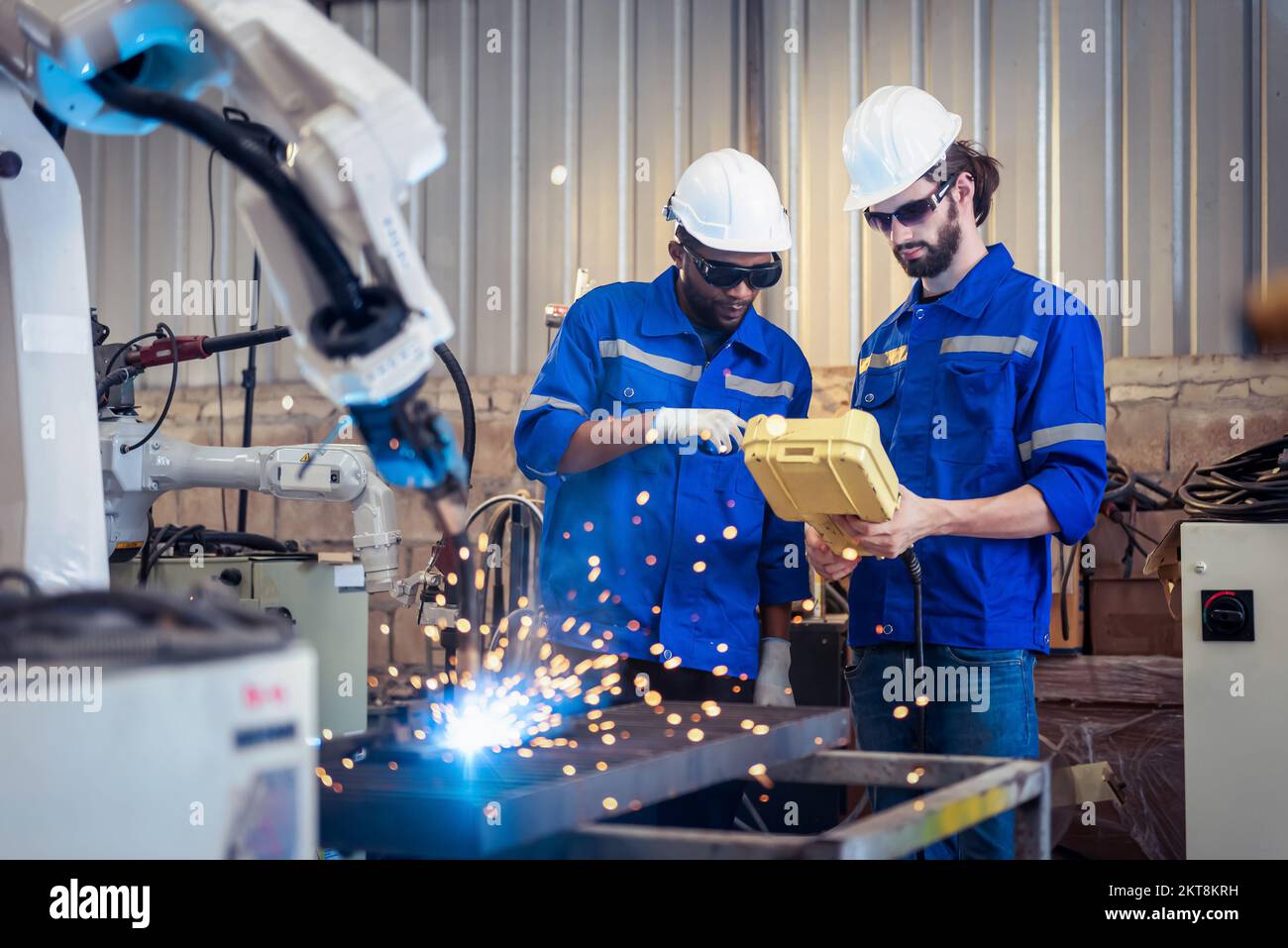 Two engineers mechanic using computer controller Robotic arm for ...