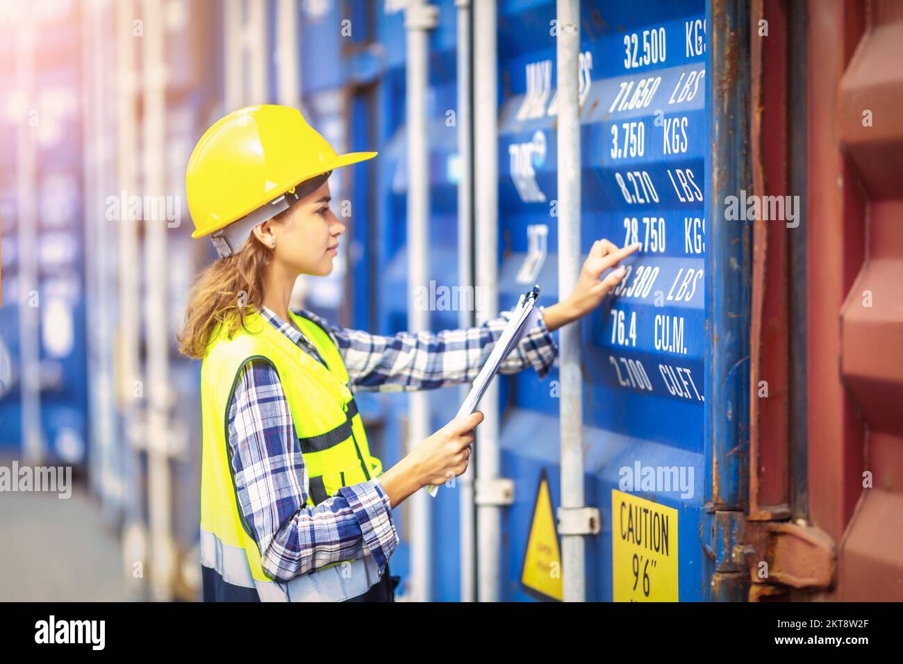 Women Engineer wears PPE checking container storage with cargo ...