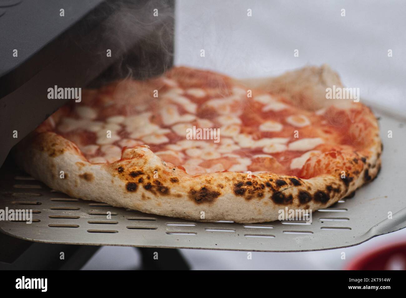 Cooking or baking hot pizza Margherita with tomato sauce and mozzarella ...