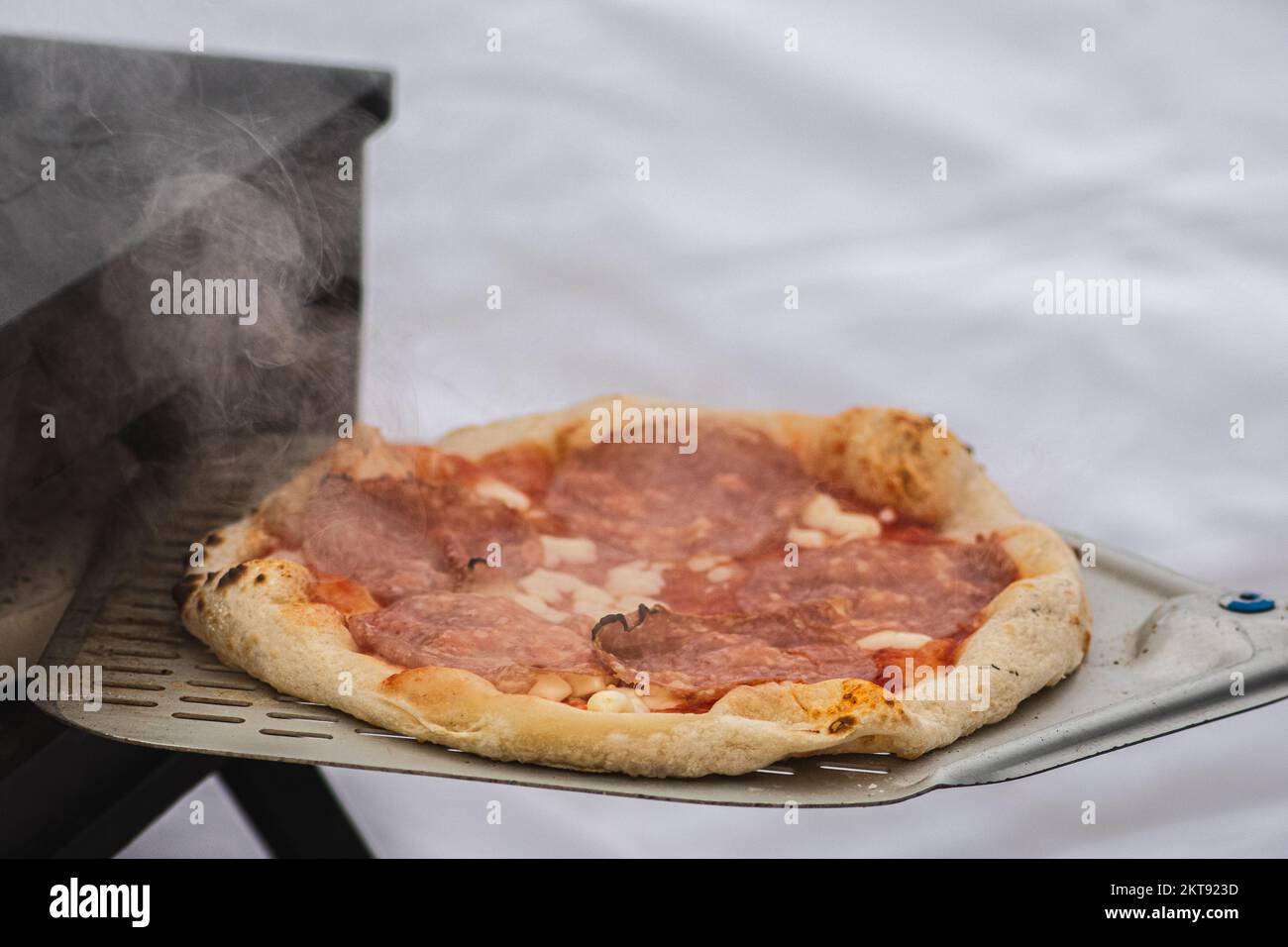 Cooking or baking hot pizza with tomato sauce, mozzarella and salami ...