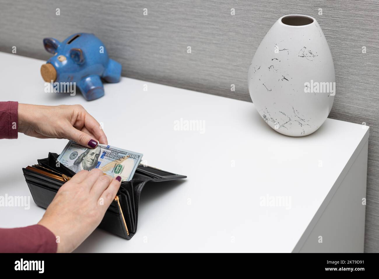 man puts a wad of dollars into his wallet. man takes money out of ...