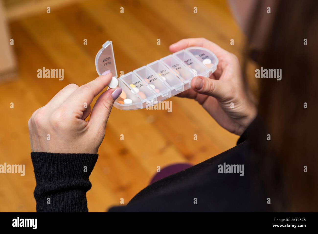 Woman taking medication from pill box. Health care and treatment ...