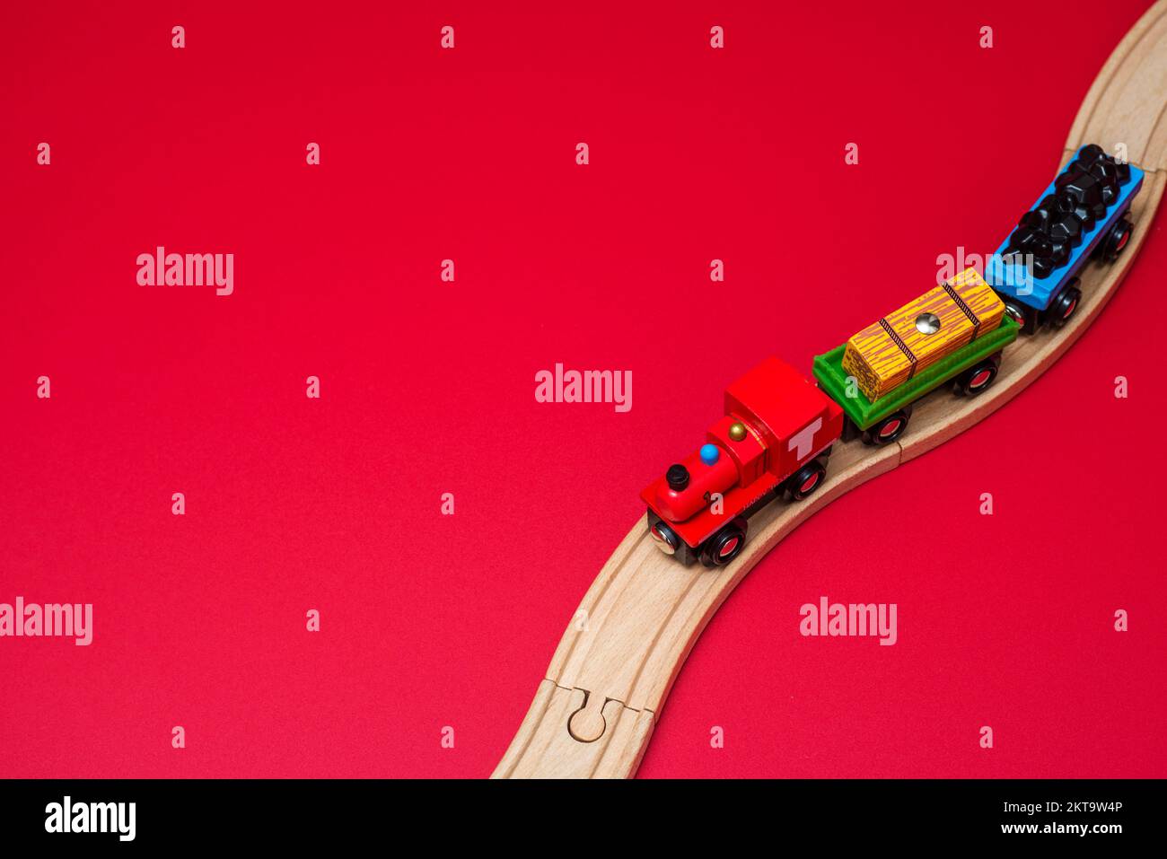 Wooden toy train on railroad on red background. Educational toys Stock ...