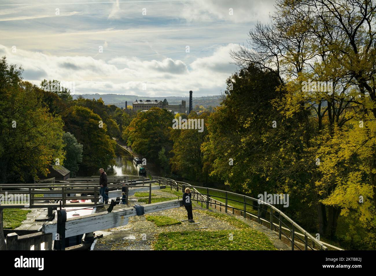 2 people by lock gates (opening gate) boats moored & sunlit Damart mill ...