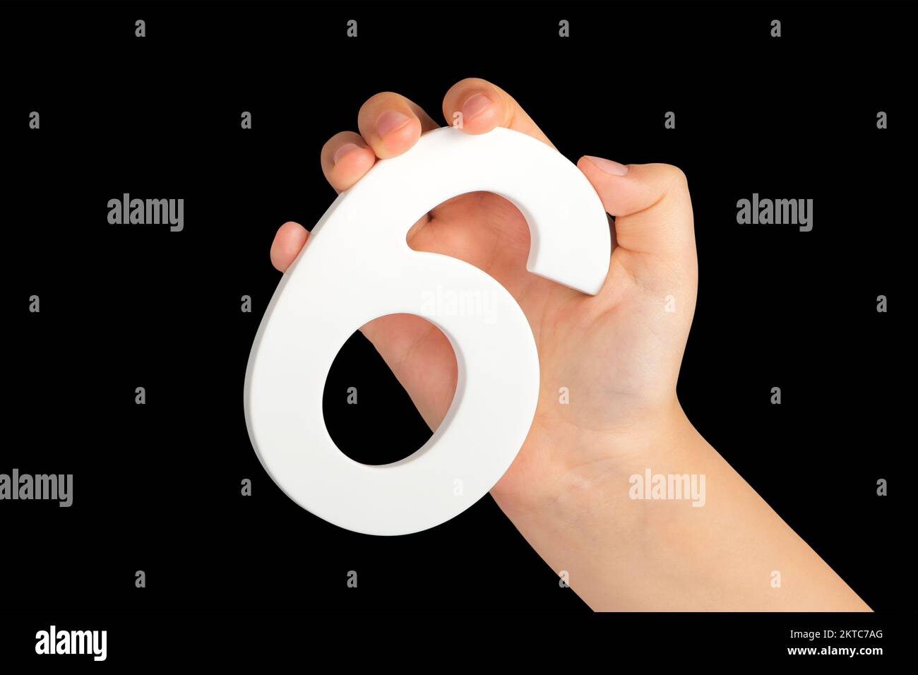 Number six in hand isolated on black background. Number six in a child ...