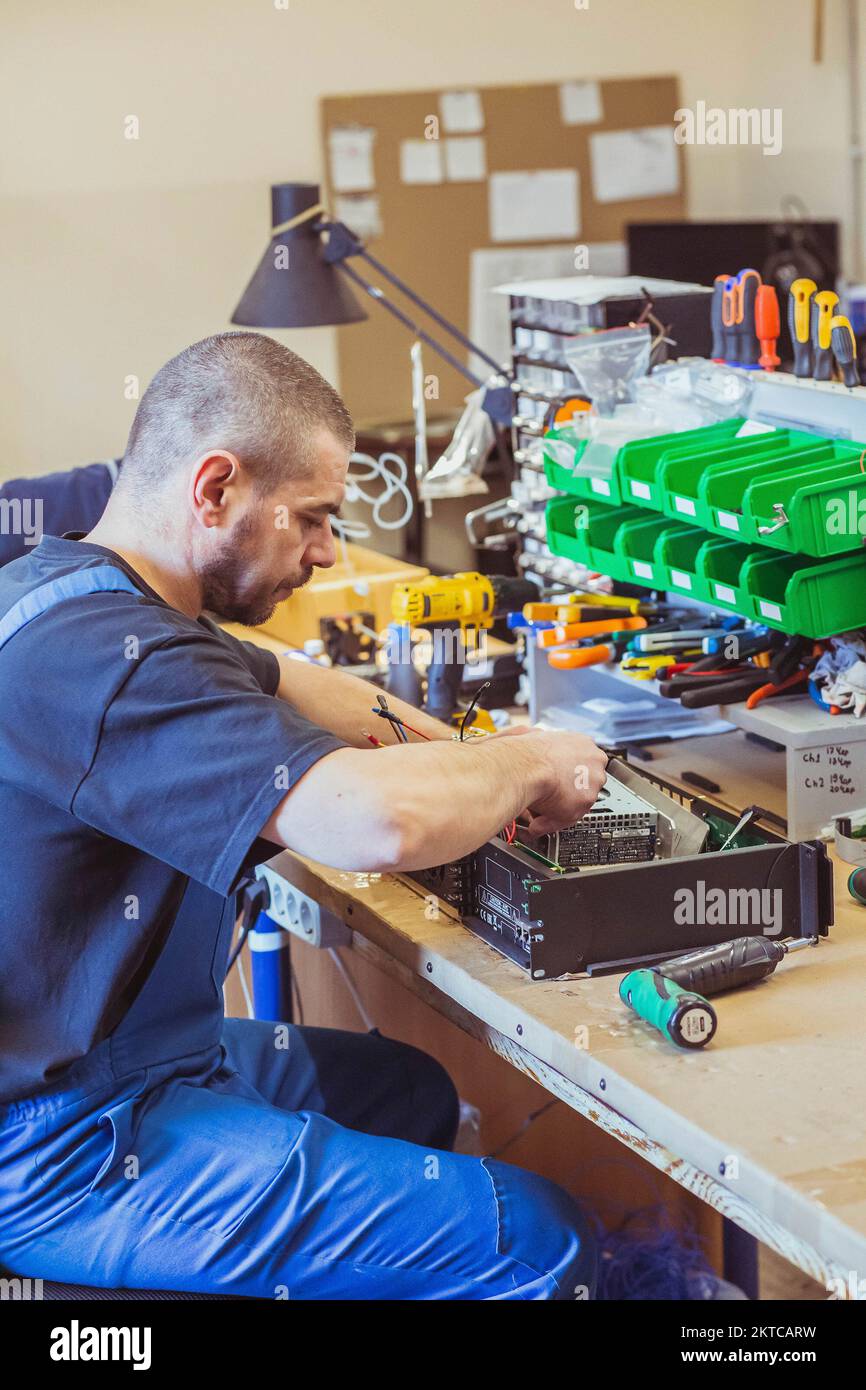 The worker assembles the amplifier to the speaker system Stock Photo ...