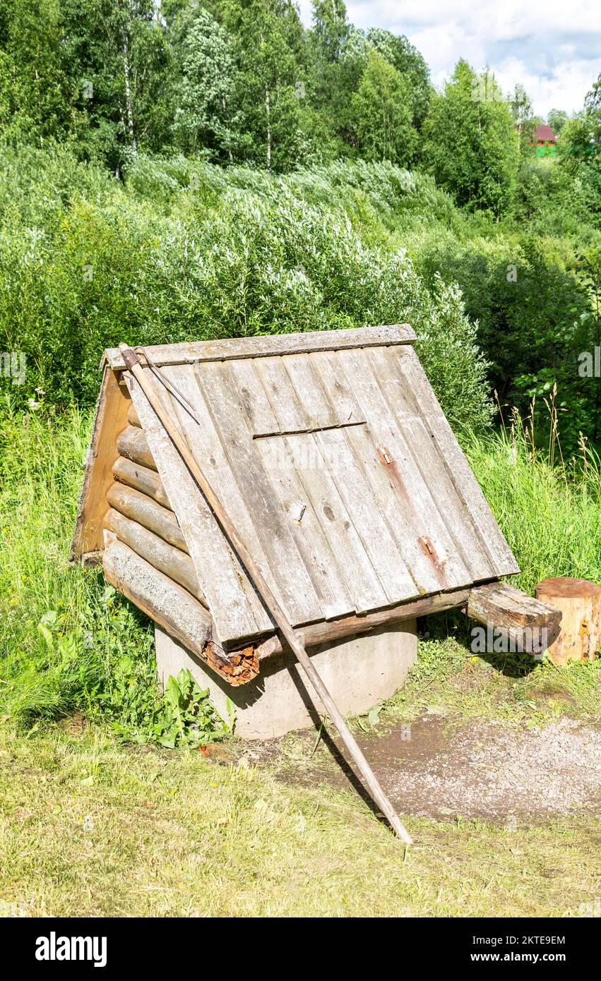 Traditional wooden water well at the countryside in summer sunny day ...