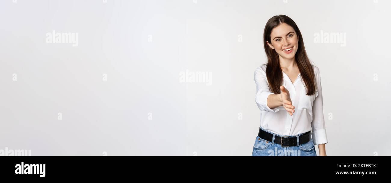Smiling, friendly corporate woman extending arm for handshake, shaking ...