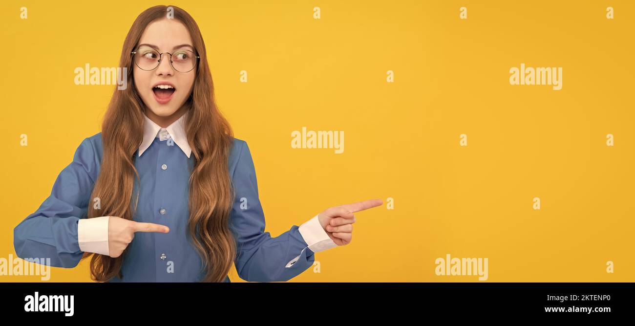 Surprised kid point fingers yellow background. Pointing for advertising ...