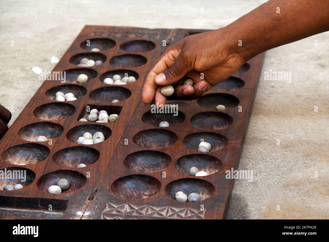 Hand playing Mancala game - a game which is very popular in Africa and ...