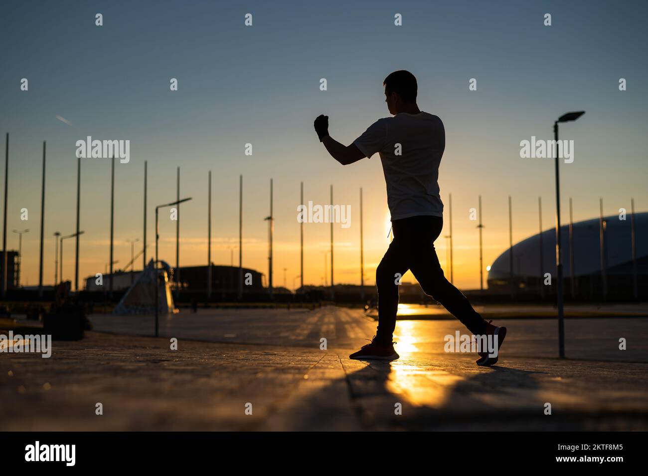 A man trains boxing at sunset outdoors Stock Photo - Alamy