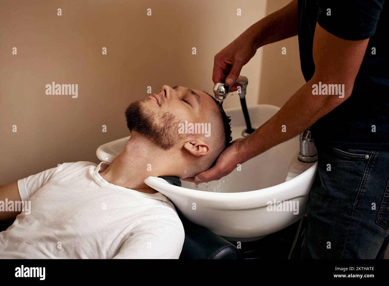 Young bearded man washing head hi-res stock photography and images - Alamy