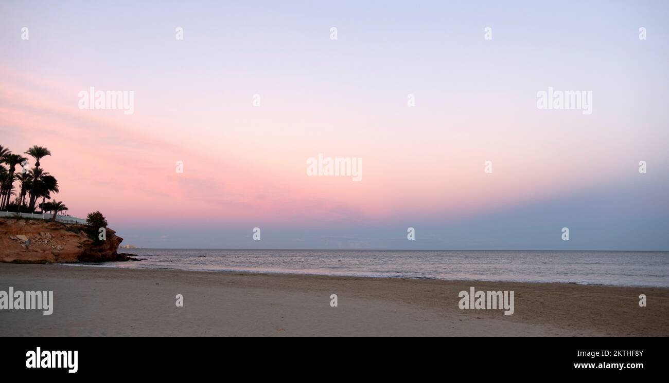 Pink sky at sunset over the beach in Spain Stock Photo - Alamy