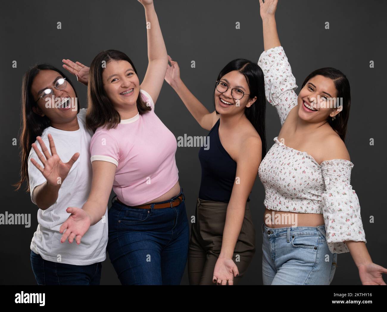 Portrait of group happy young hispanic people on studio background ...