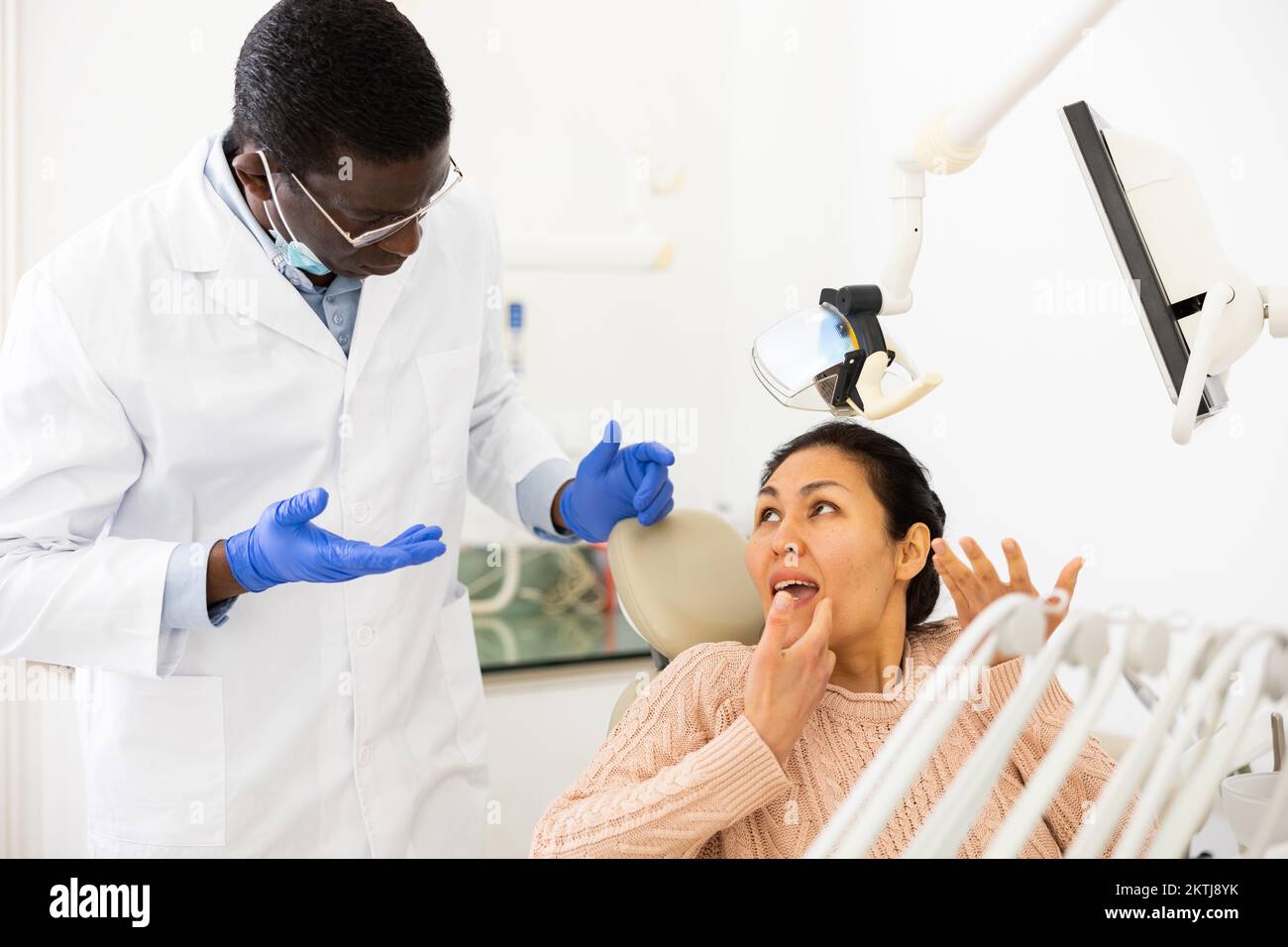 Woman talking with dentist about tooth problem in dental clinic Stock ...