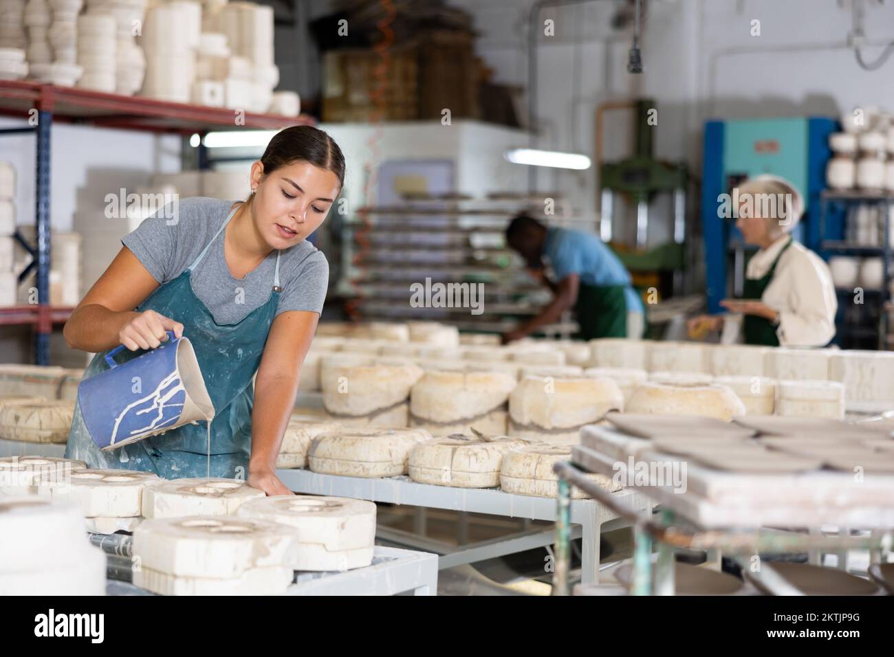 Pouring slip mass into plaster molds at pottery factory Stock Photo - Alamy