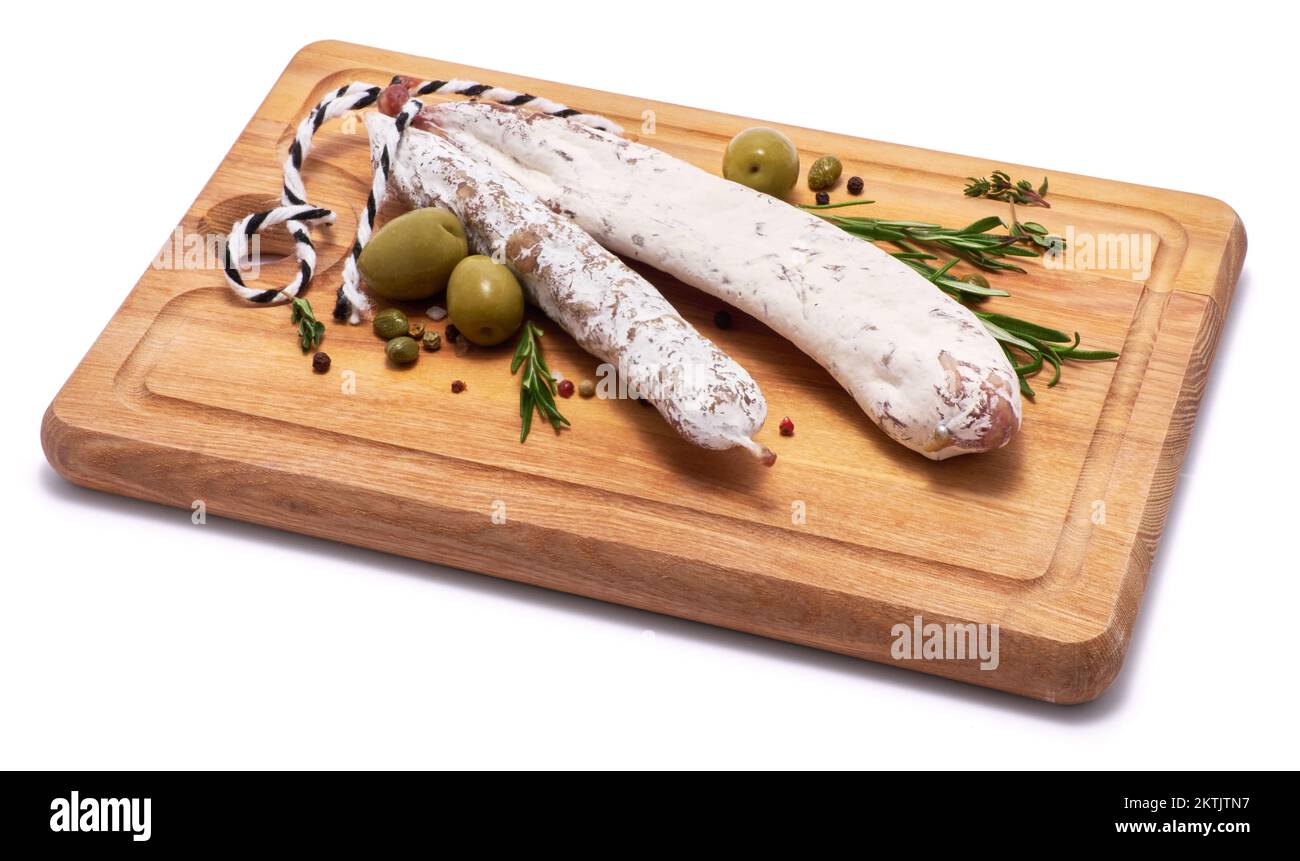 Spanish Fuet thin dried salami sausage on wooden cutting board isolated ...