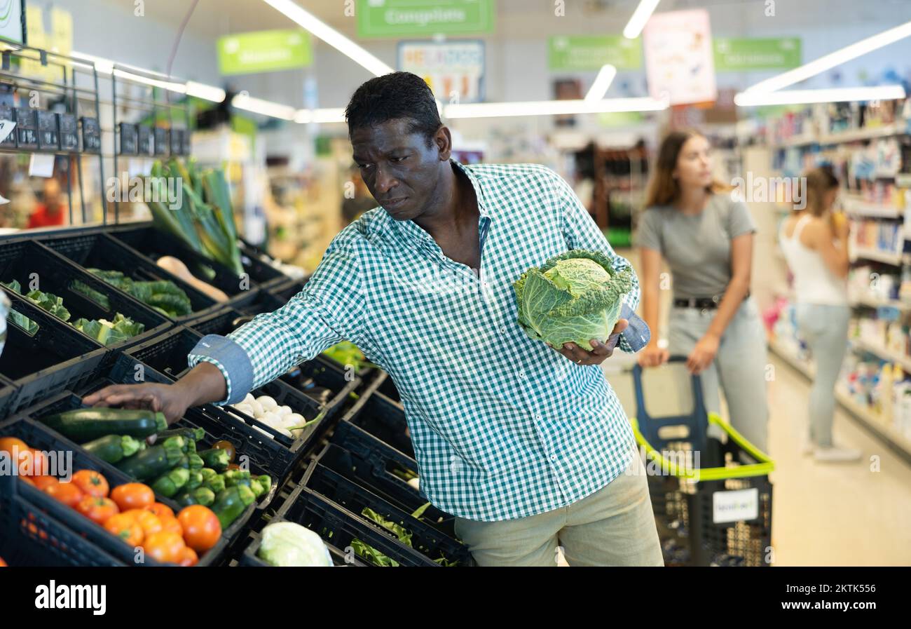 Man choosing vegetables in grocery store Stock Photo - Alamy
