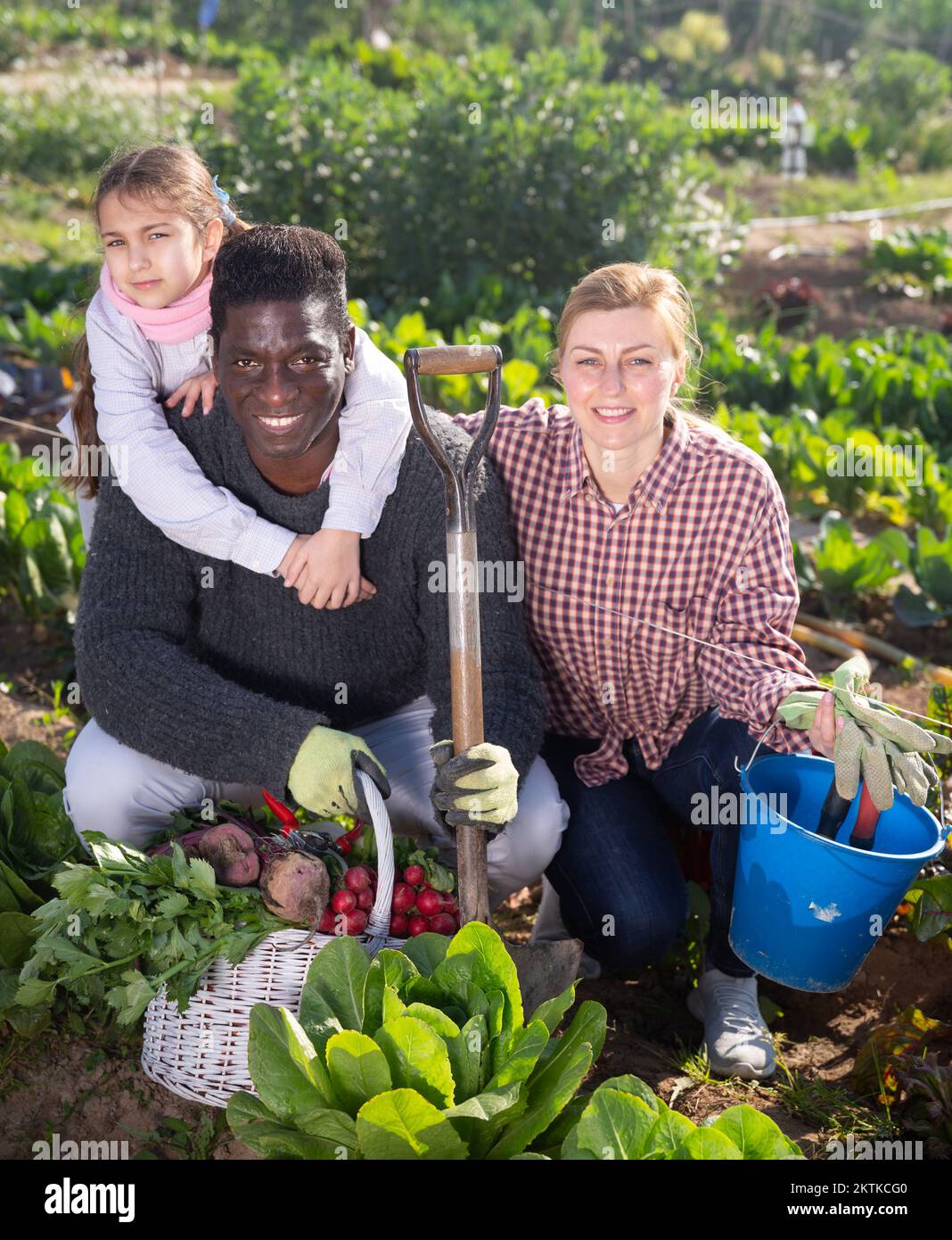 Portrait of a multinational family in the vegetable garden with a ...