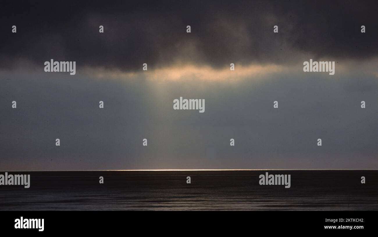 sunset at the adrian sea with dark clouds and spectacular reflection at ...
