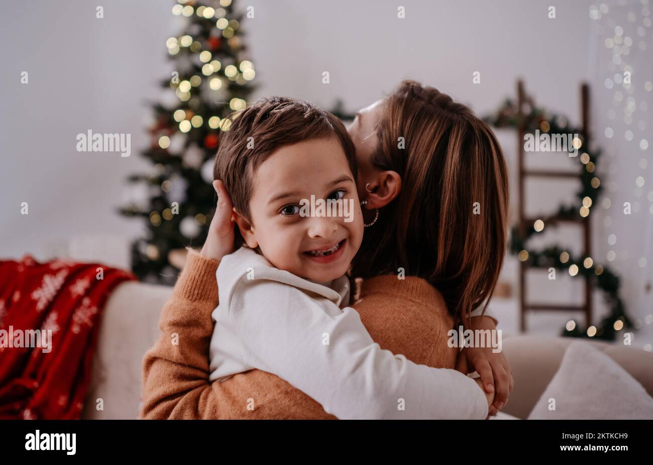 Mother keeps in arms, tender embrace, gently hugs child kid son boy in ...