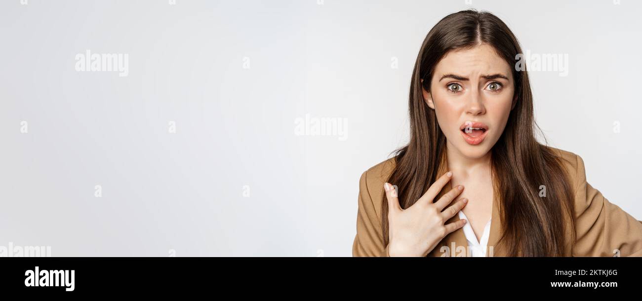 Shocked, offended businesswoman pointing at herself, looking insulted ...