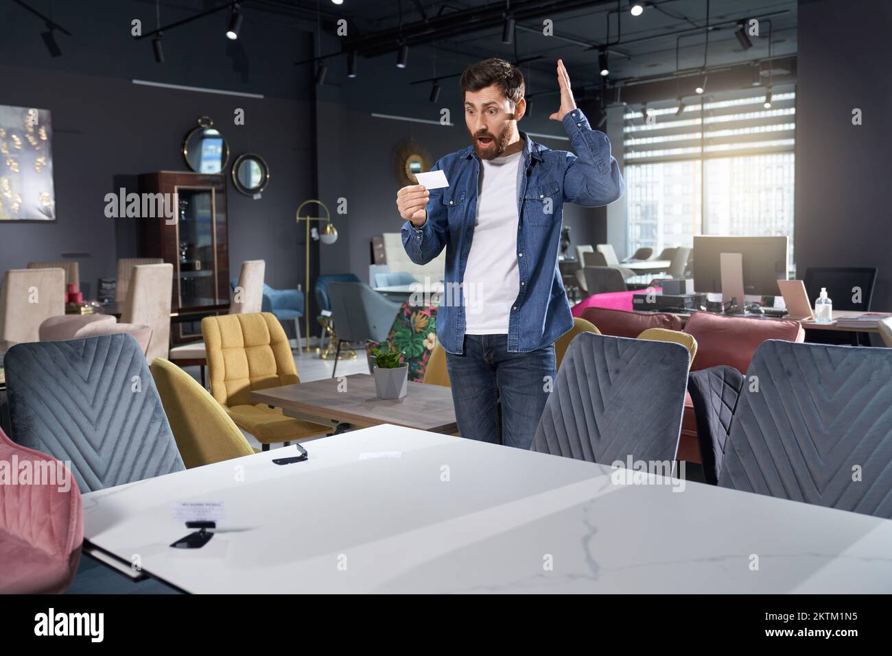 Excited male buyer looking at price tag with open mouth, cannot believe ...