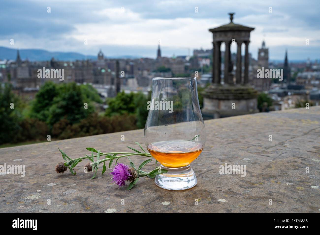 Dram glass of single malt scotch whisky and view from Calton hill to ...