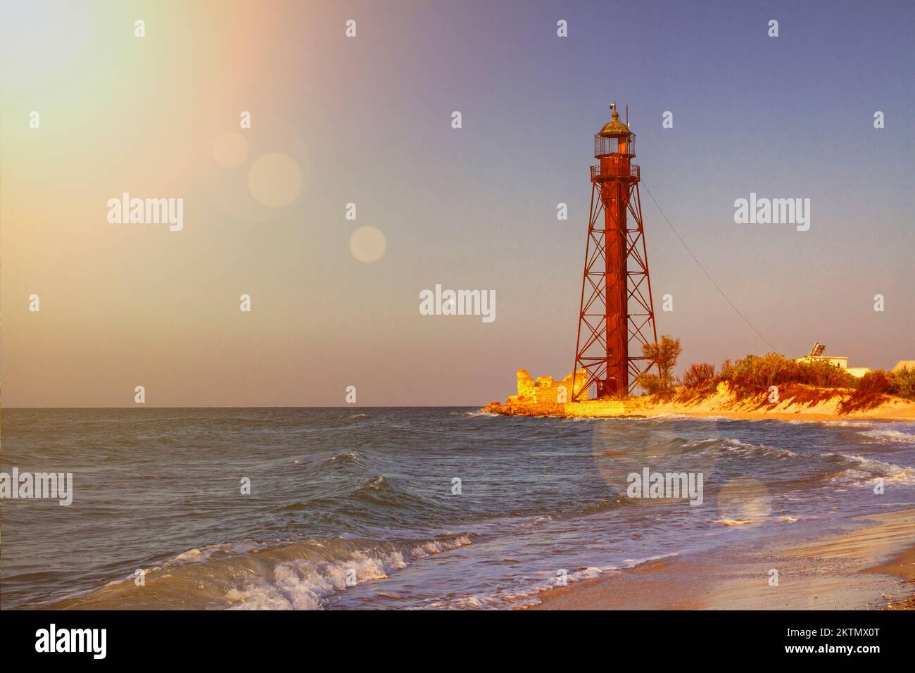 Old rusty abandoned lighthouse on the sea coast during sunrise near the ...